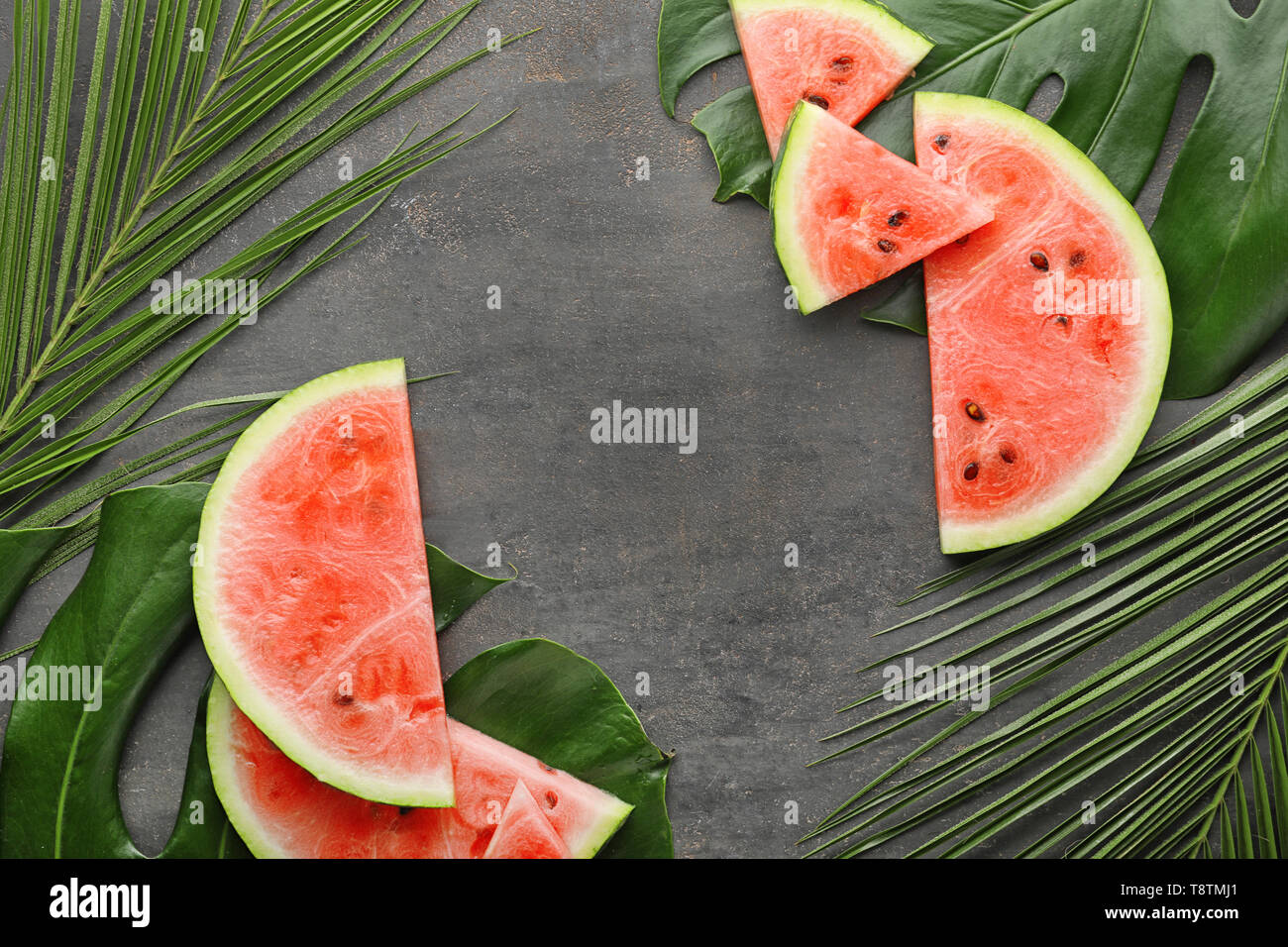 Summer composition with tropical leaves and slices of watermelon on ...