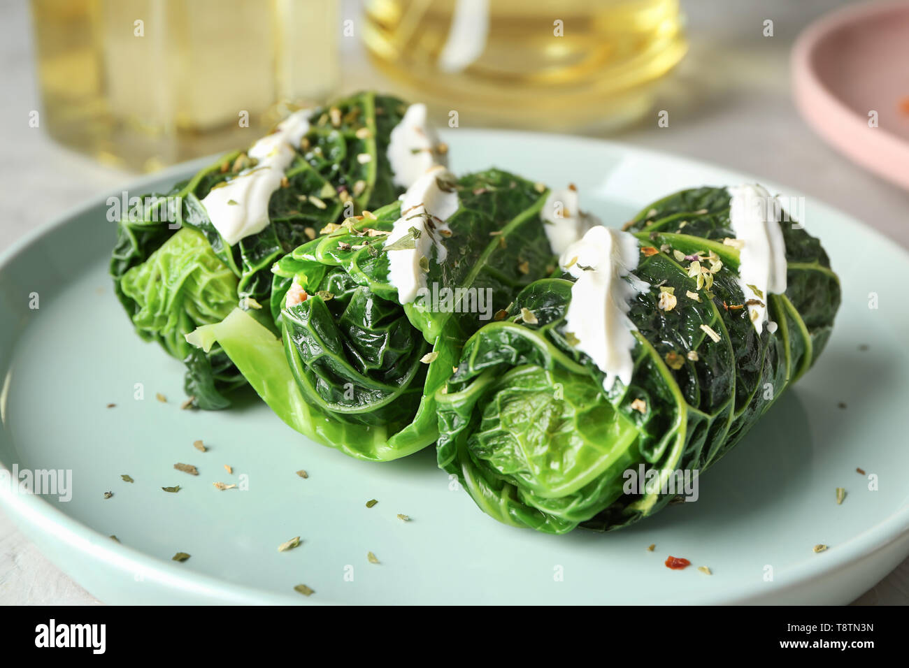 Stuffed cabbage leaves with sour cream on plate, closeup Stock Photo ...