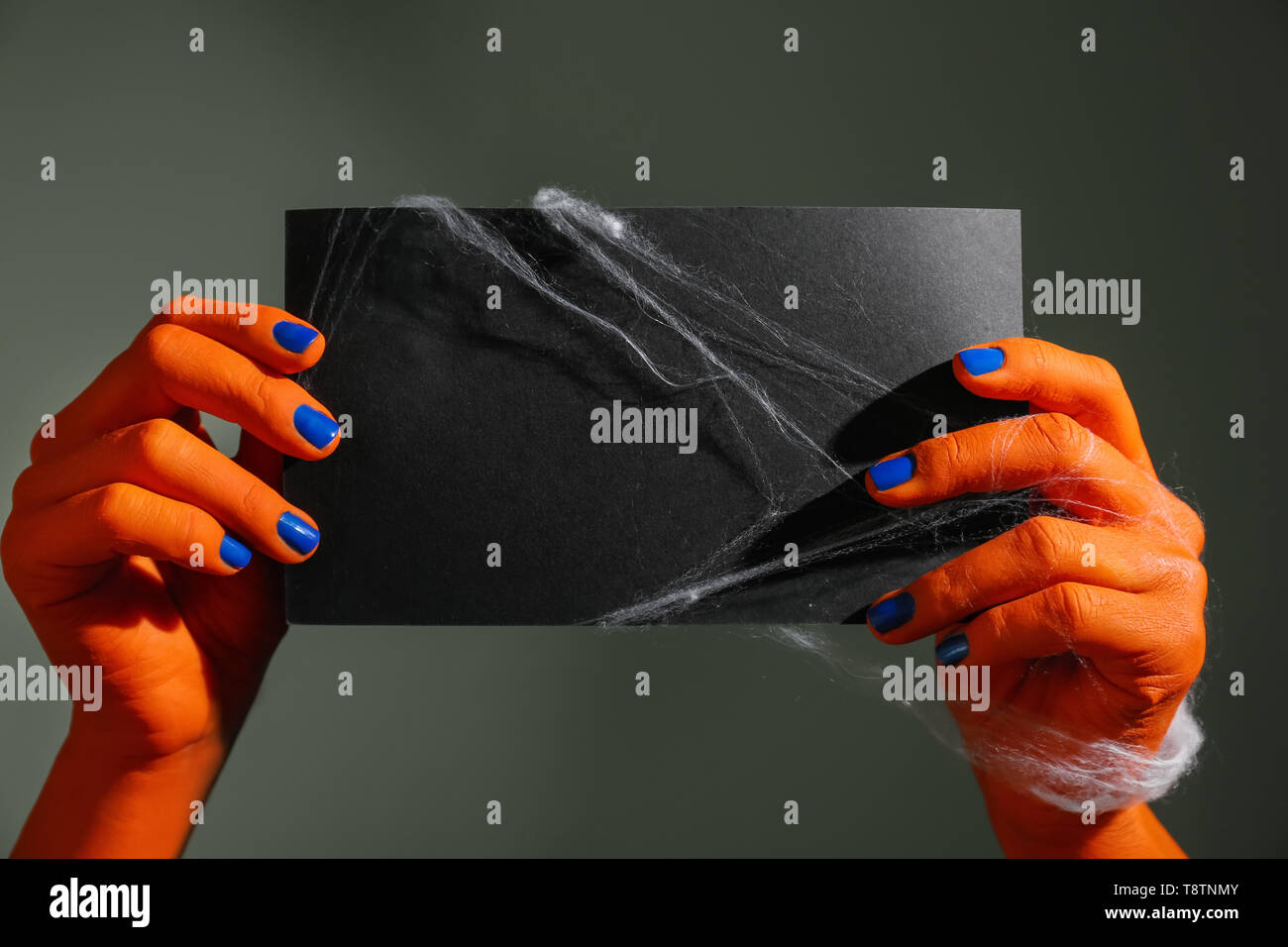 Monster holding blank card on dark background Stock Photo - Alamy