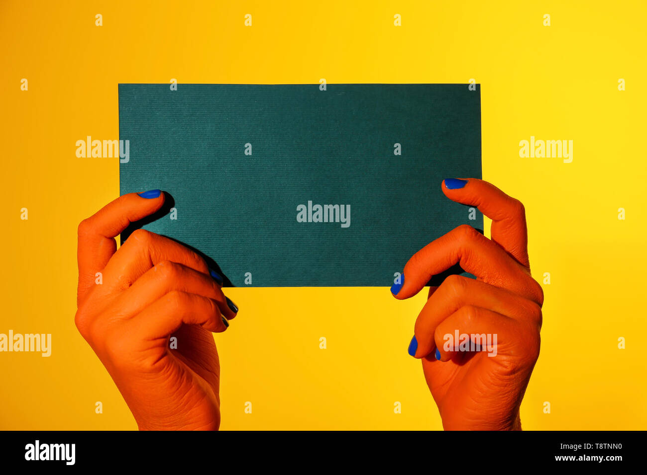 Monster holding blank card on color background Stock Photo - Alamy