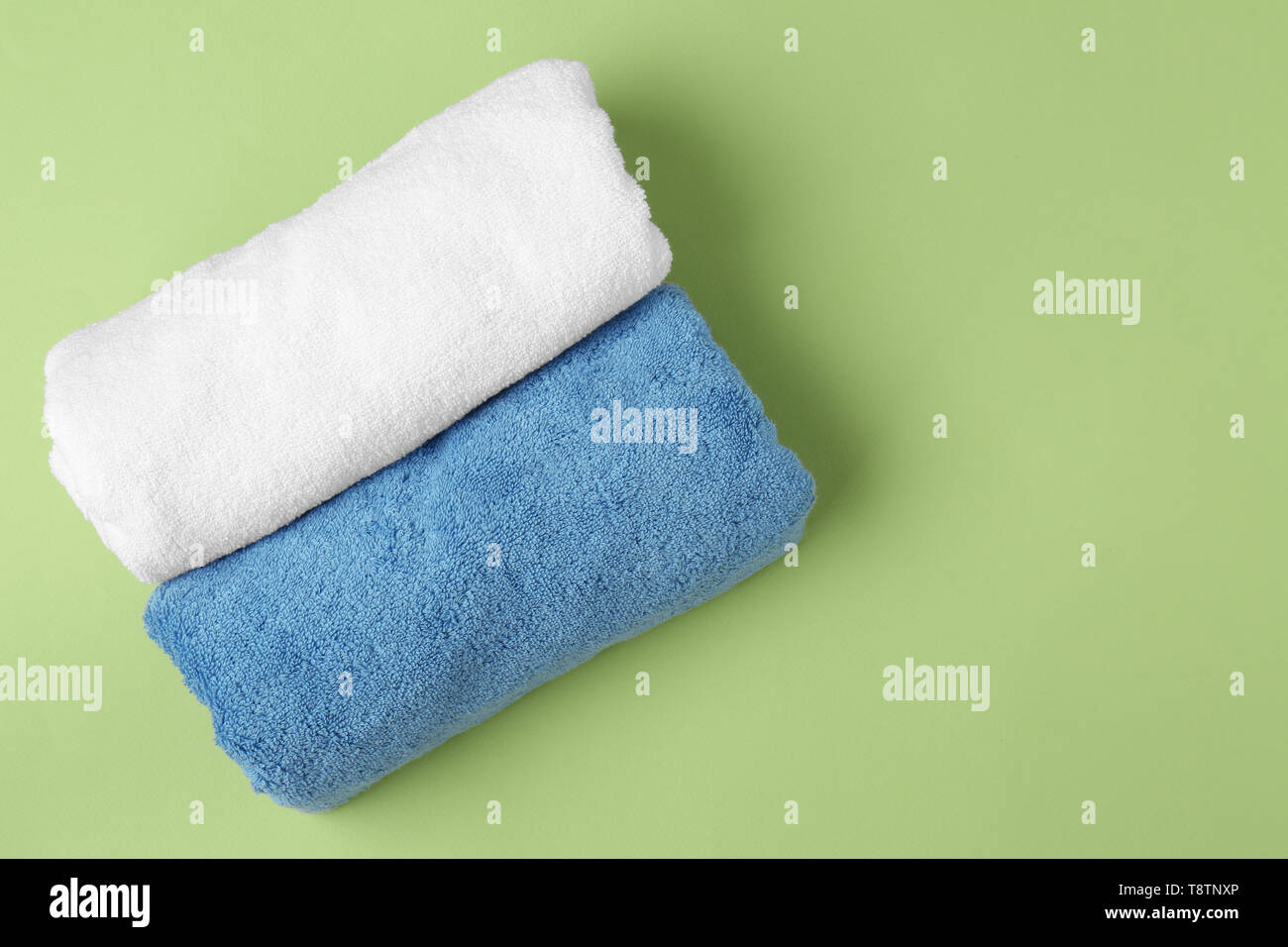 Rolled clean soft towels on color background Stock Photo - Alamy