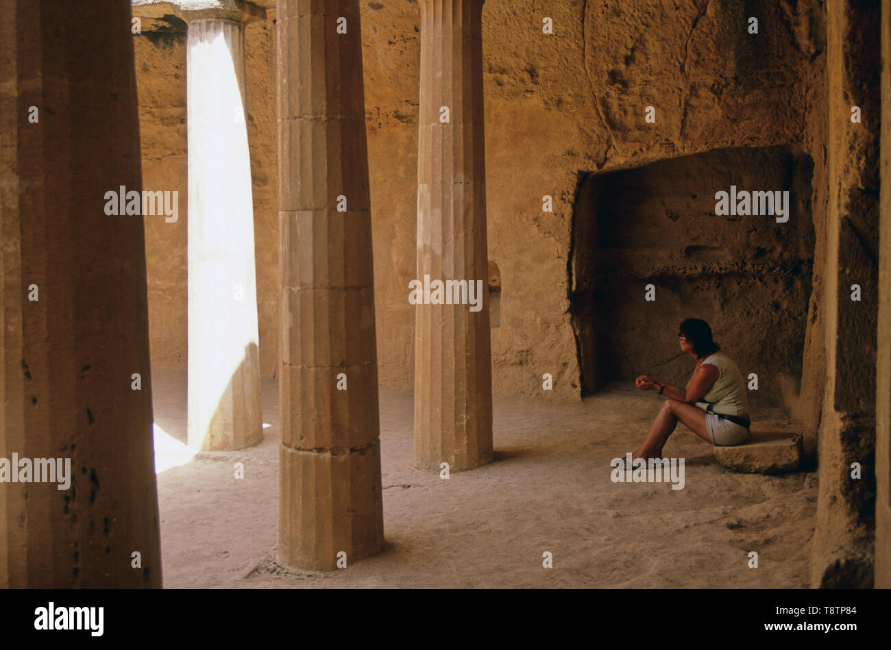 Female visitor inside a burial chamber with fluted doric columns, Tombs ...