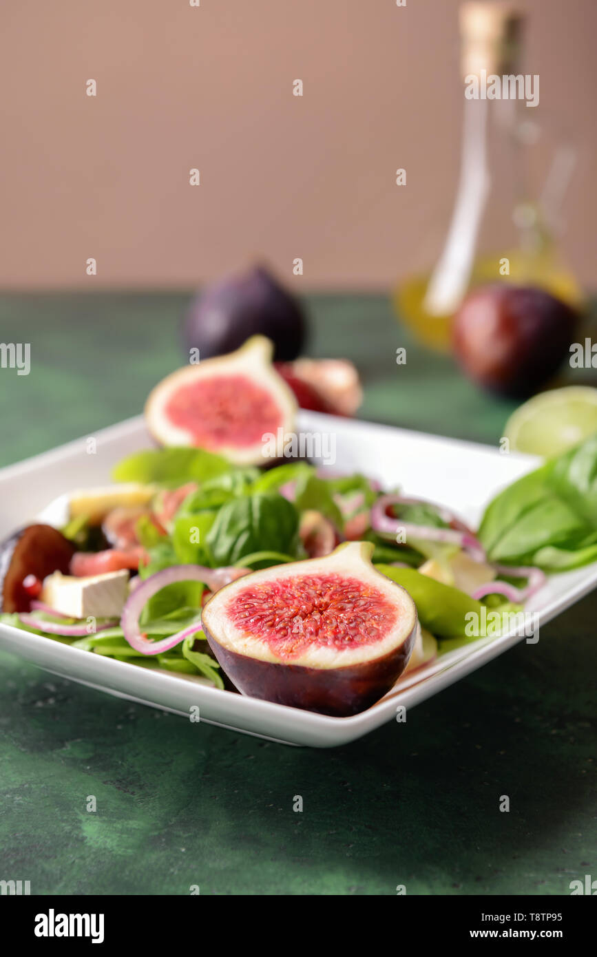 Plate with delicious fig salad on color table Stock Photo - Alamy