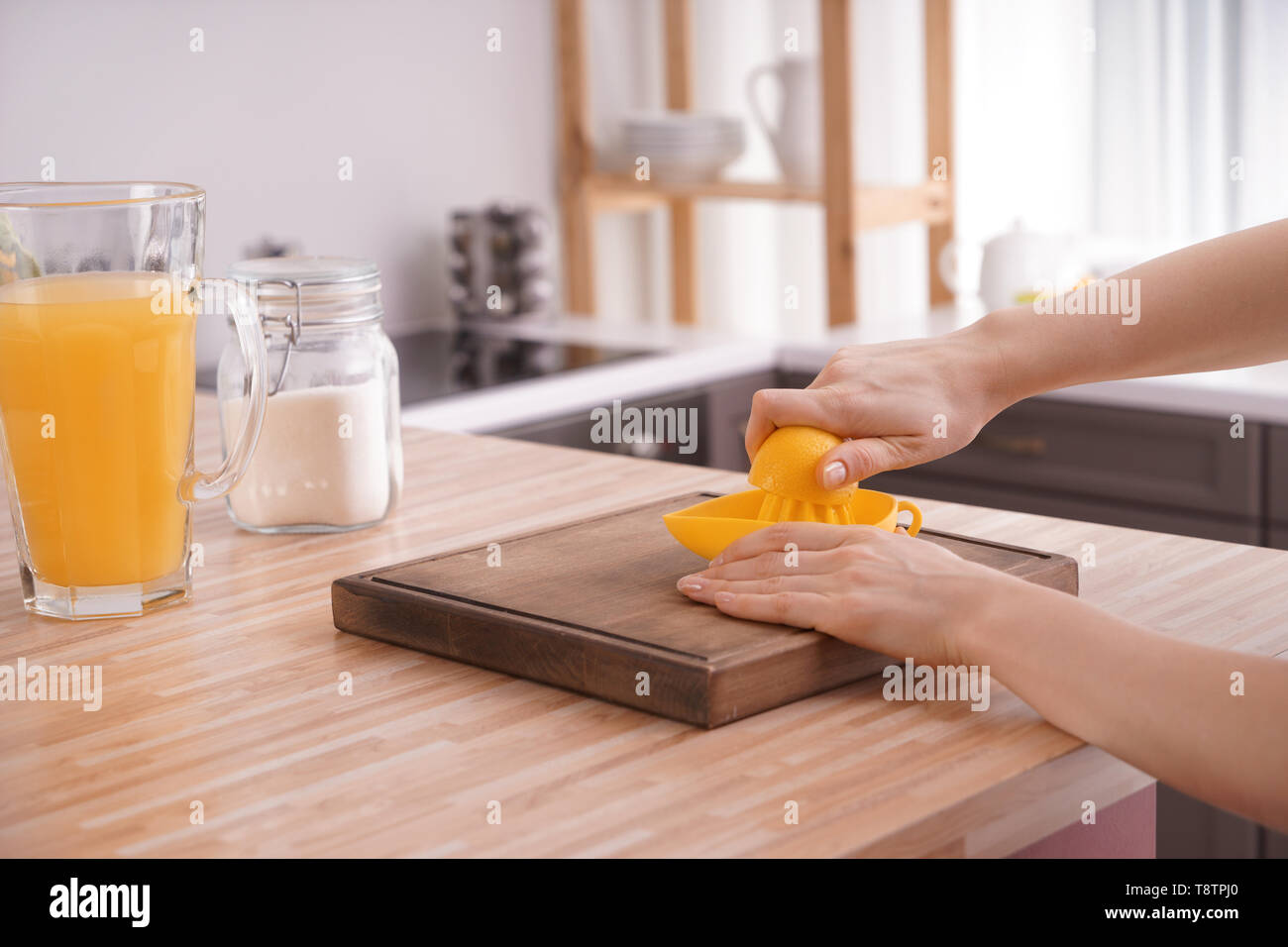Woman squeezing fresh lemon juice in kitchen Stock Photo - Alamy