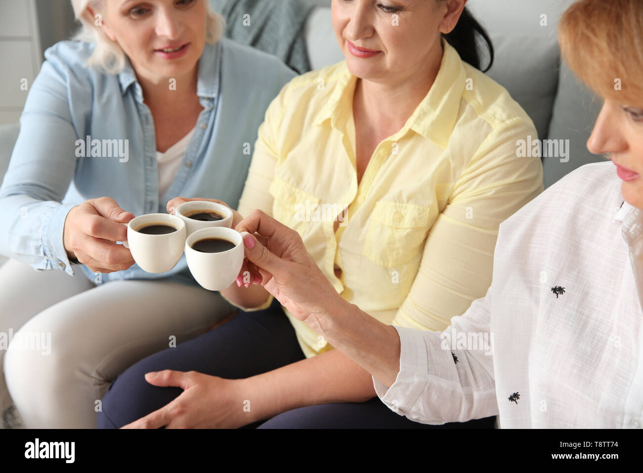 Beautiful mature women drinking coffee at home Stock Photo - Alamy