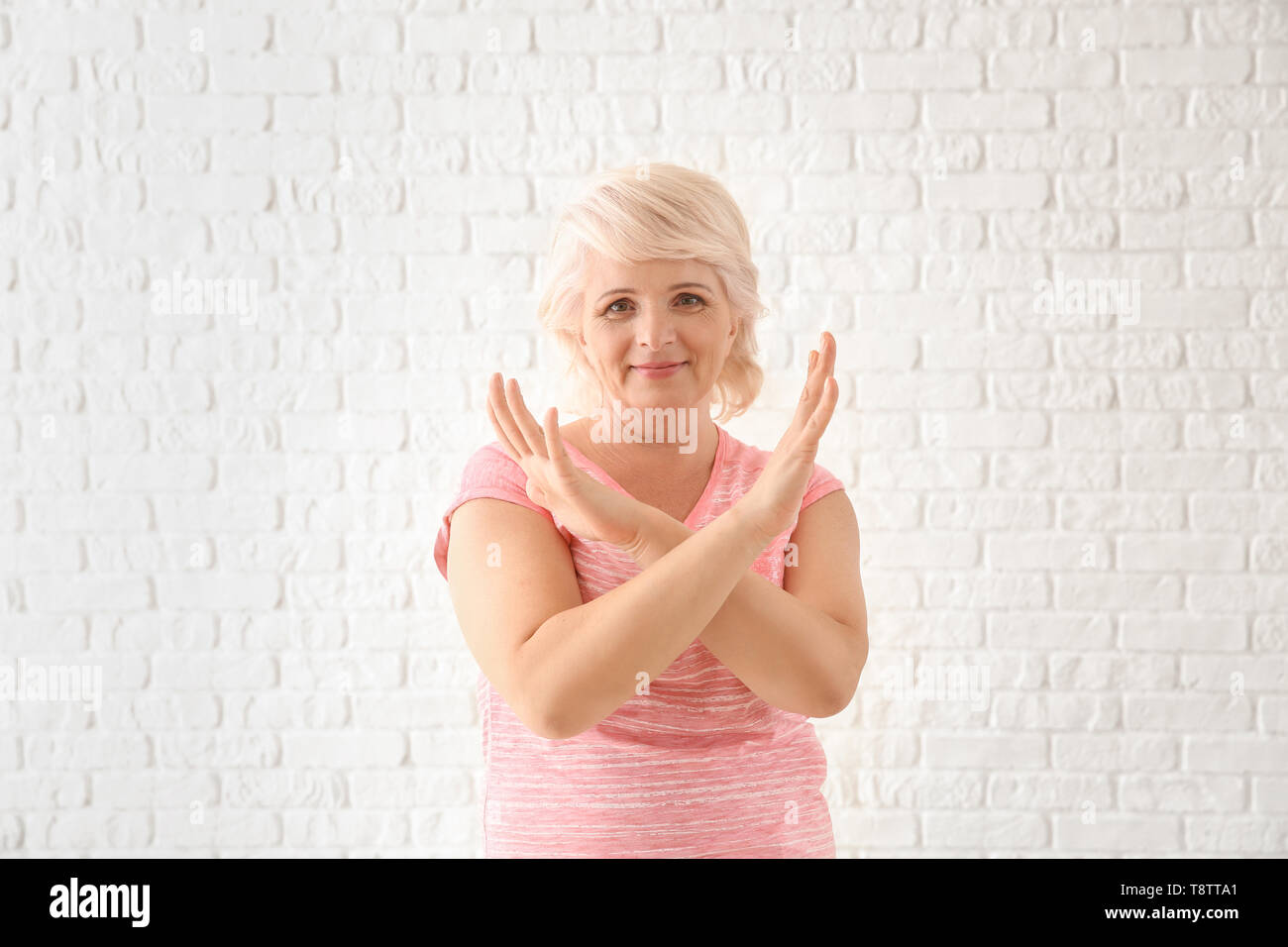 Portrait of mature woman rejecting something on white background Stock ...