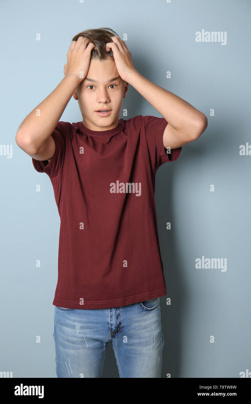 Stressed teenage boy on color background Stock Photo - Alamy