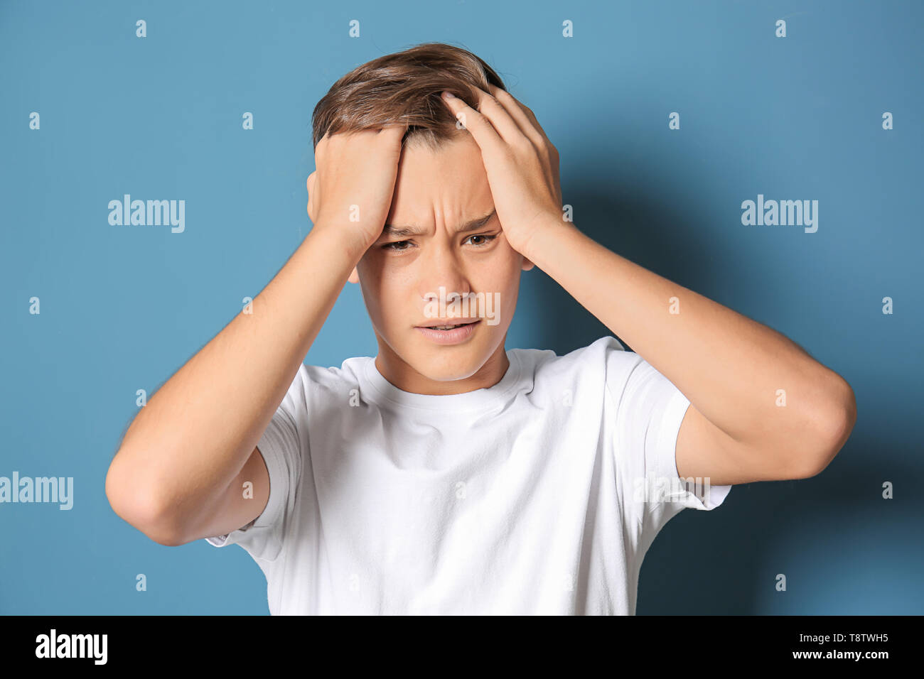 Stressed teenage boy on color background Stock Photo - Alamy