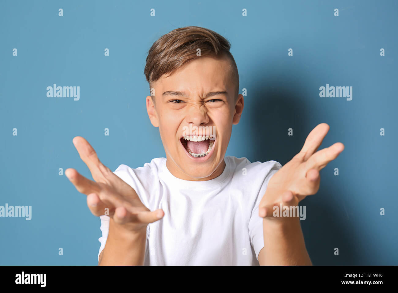 Angry teenage boy on color background Stock Photo - Alamy