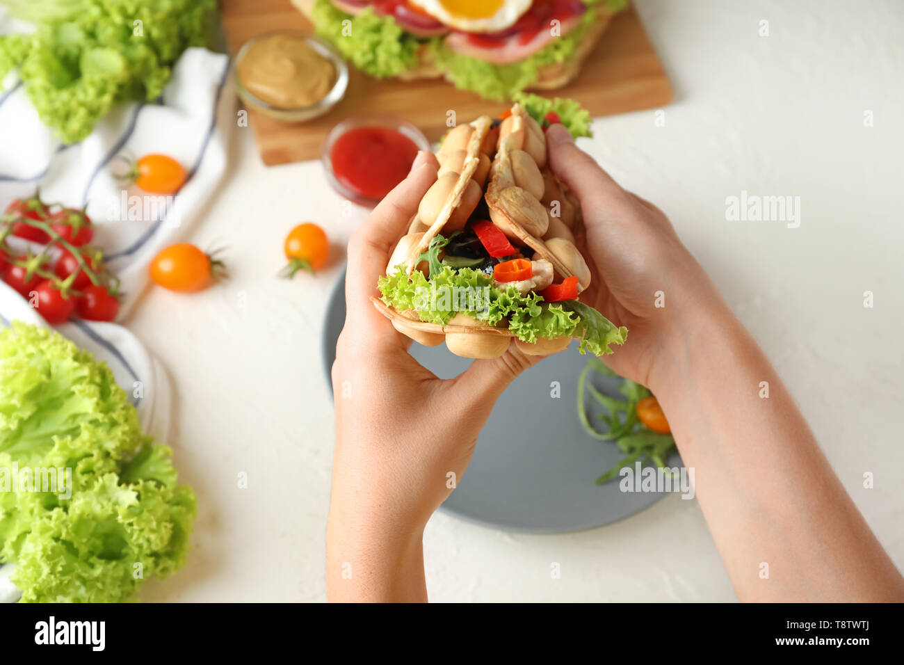 Woman eating delicious bubble waffle, closeup Stock Photo - Alamy