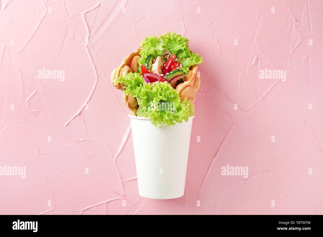Cup with delicious bubble waffle on color background Stock Photo - Alamy
