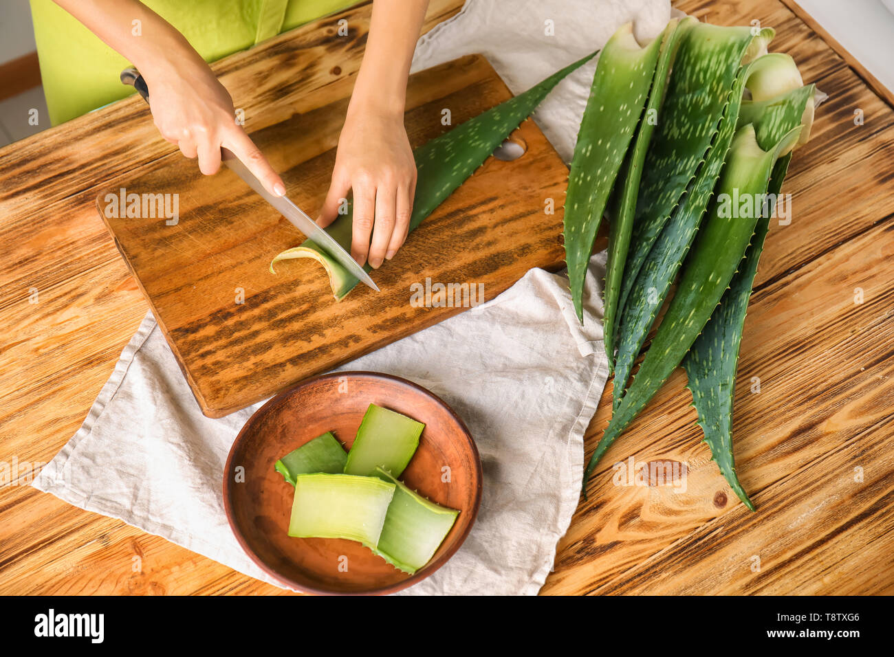 Woman cutting aloe vera leaf on wooden board Stock Photo - Alamy