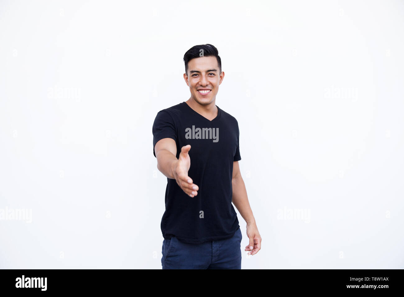 Young handsome man smiling and offering handshake as welcoming. Successful business ...