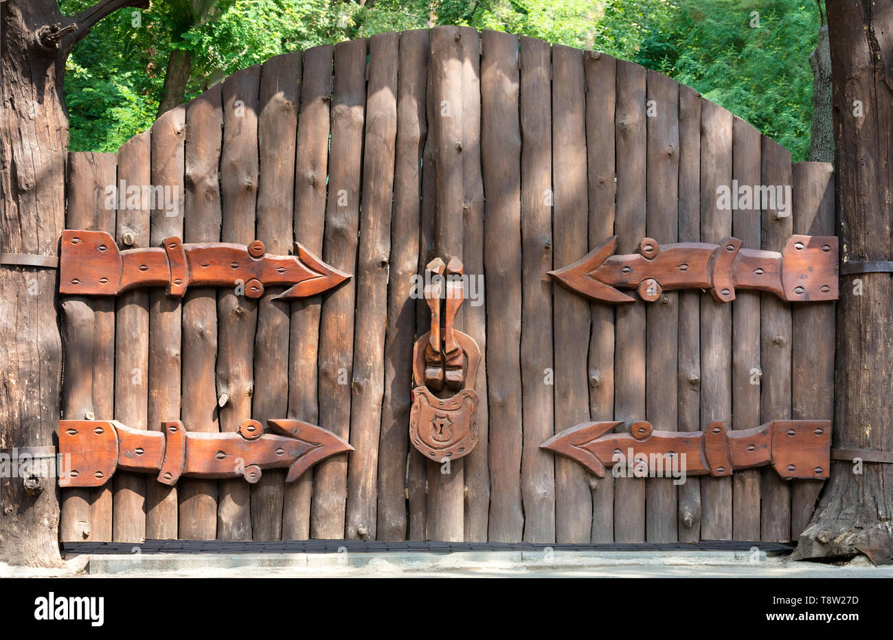 The old and mysterious wooden gate is closed to a large wooden castle ...