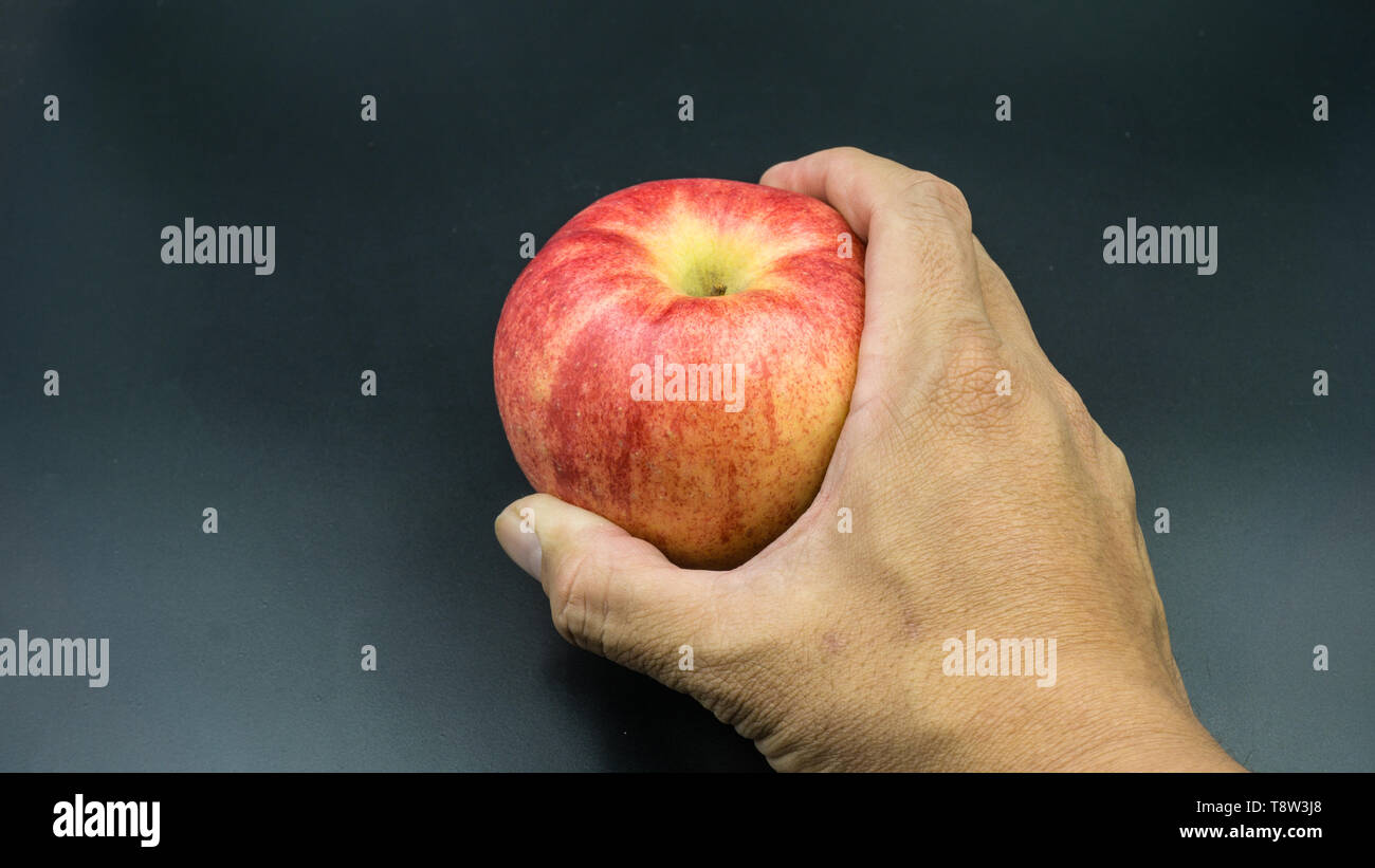 Hand Grab Apple in Black Background Stock Photo - Alamy
