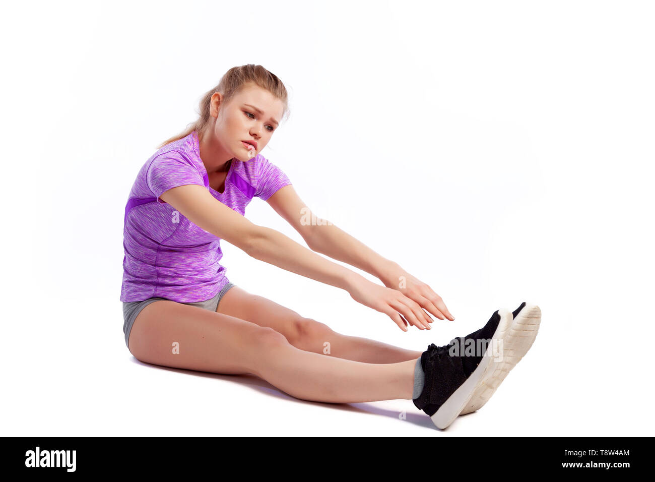 Young woman in sports clothes smilling, possing and stretching on the ...