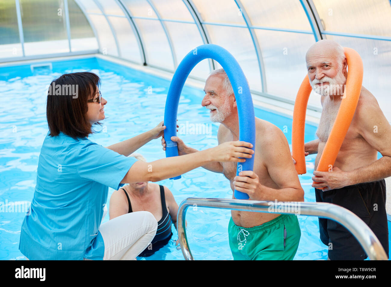 Senior and therapist together at the hydrotherapy in the swimming pool ...