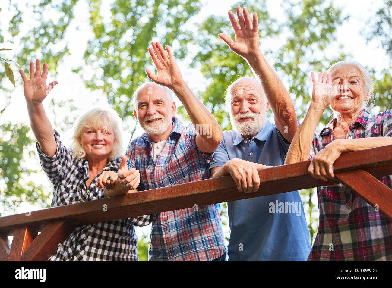 Cheerful seniors waving from a bridge on a summer outing Stock Photo ...