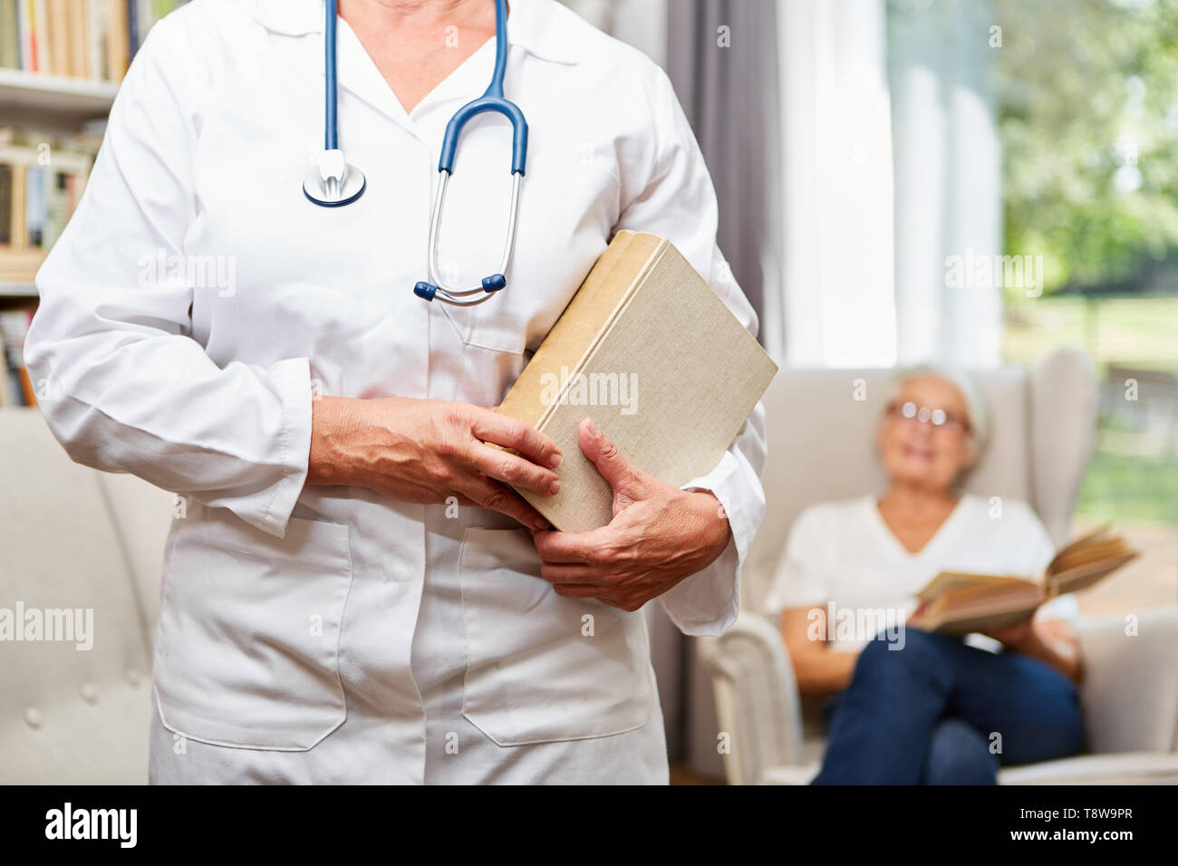 Female doctor with a book to borrow in the library in the retirement ...
