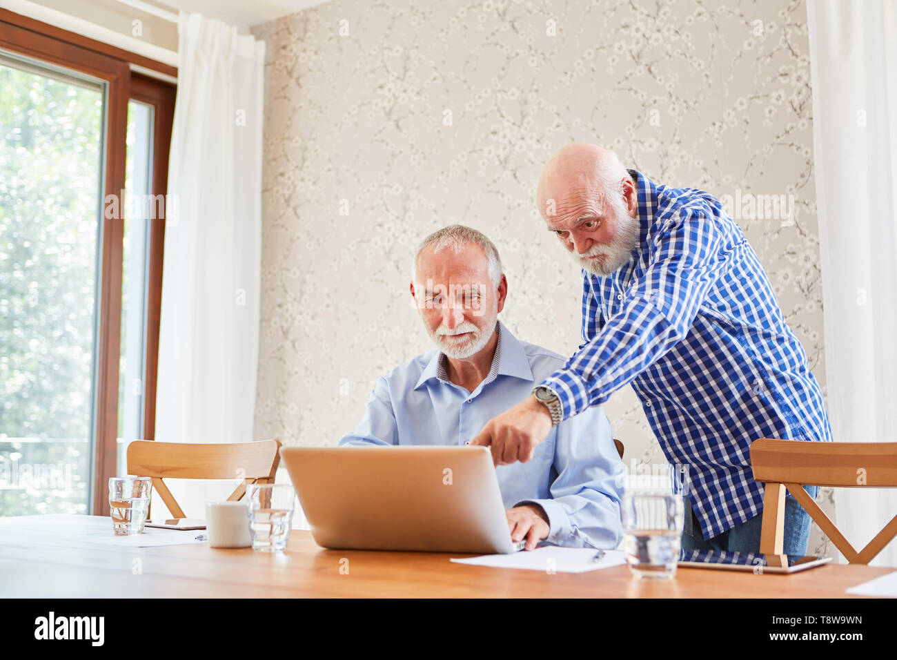 Two seniors in teamwork at laptop computer in a computer class Stock ...