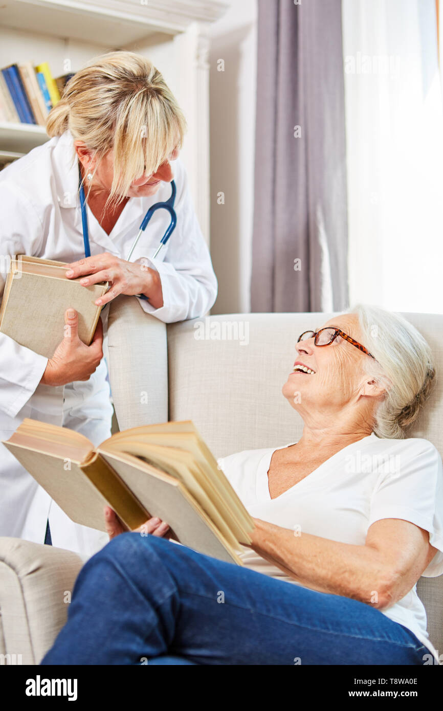Female doctor and senior woman talk about books in the library at the ...