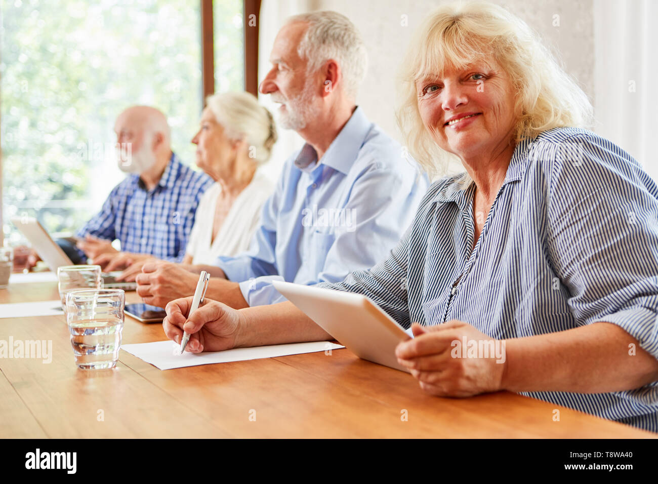 Group of seniors is learning in a computer course with tablet computer ...