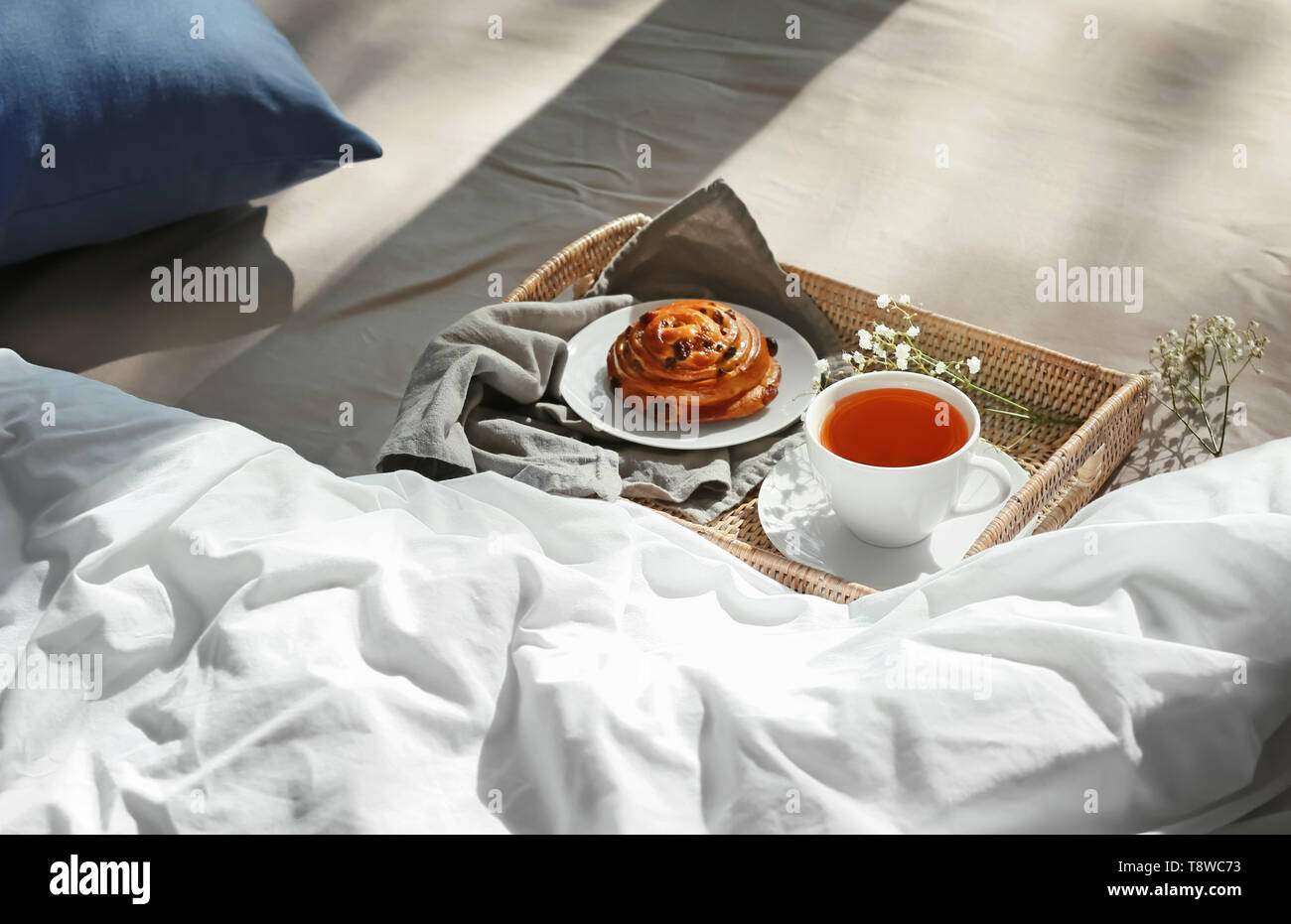 Wicker tray with delicious breakfast on bed Stock Photo - Alamy