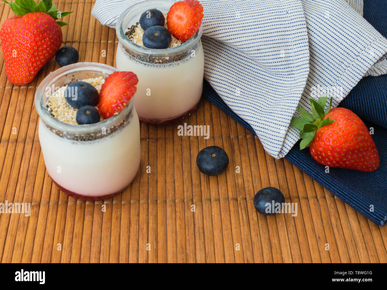 Two portions of homemade yogurt with oat, seeds and berries. Summer ...