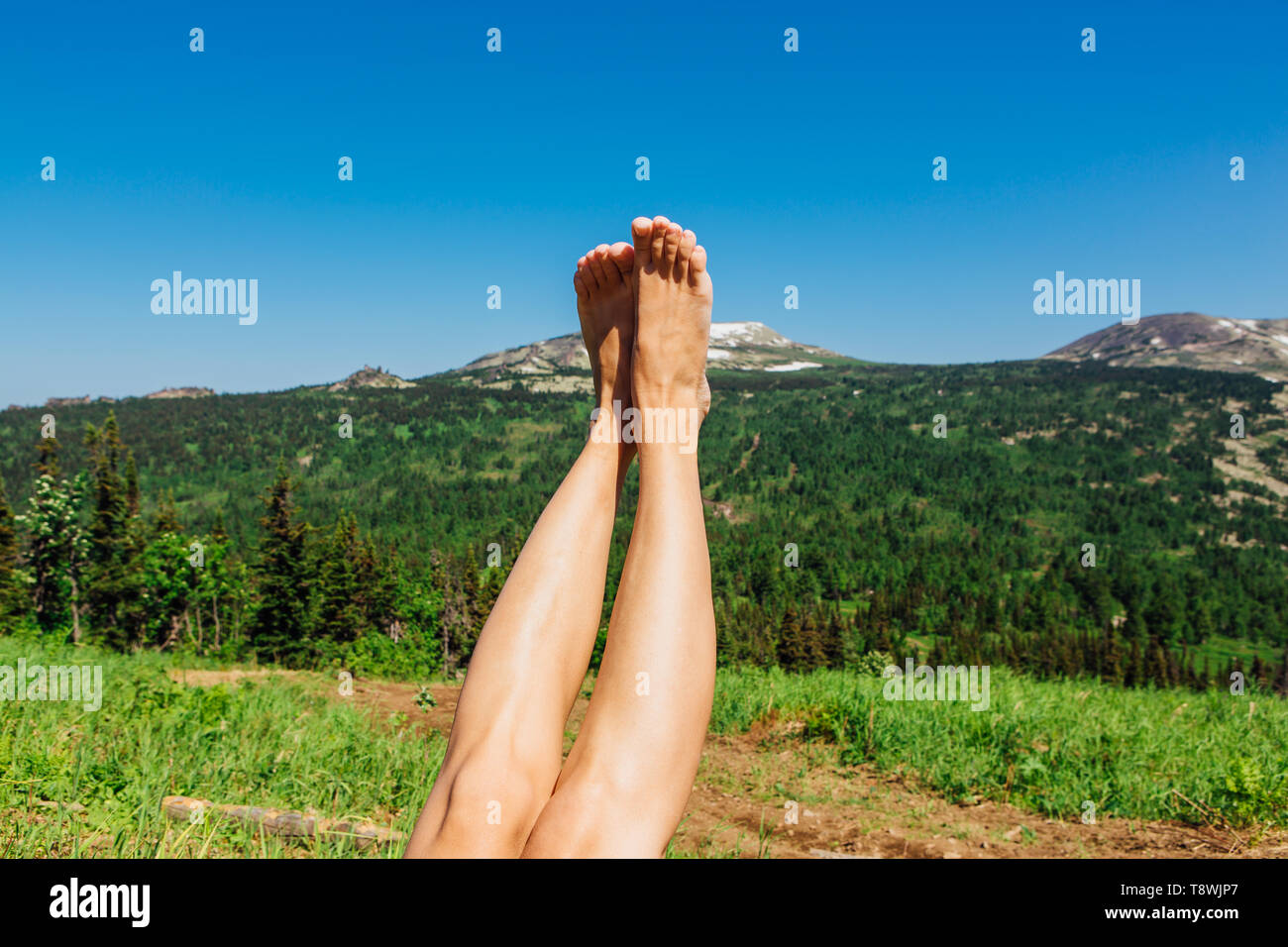 Female feet up infront of the clear blue sky and mountains Stock Photo ...