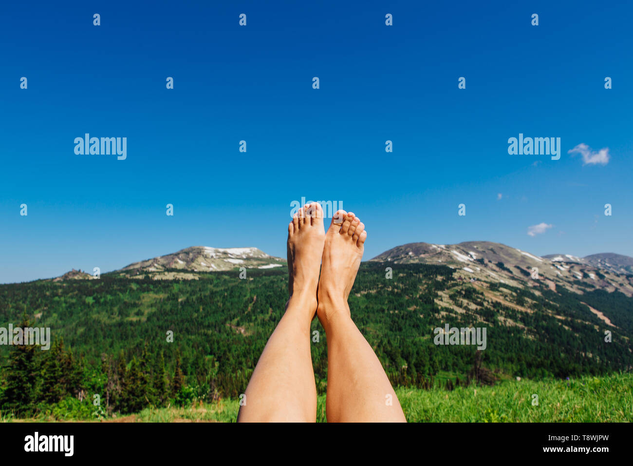 Female feet up infront of the clear blue sky and mountains Stock Photo ...