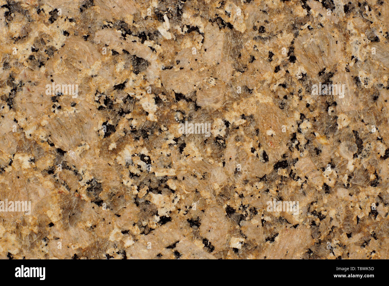 Natural stone yellow-brown granite with dark patches Stock Photo - Alamy