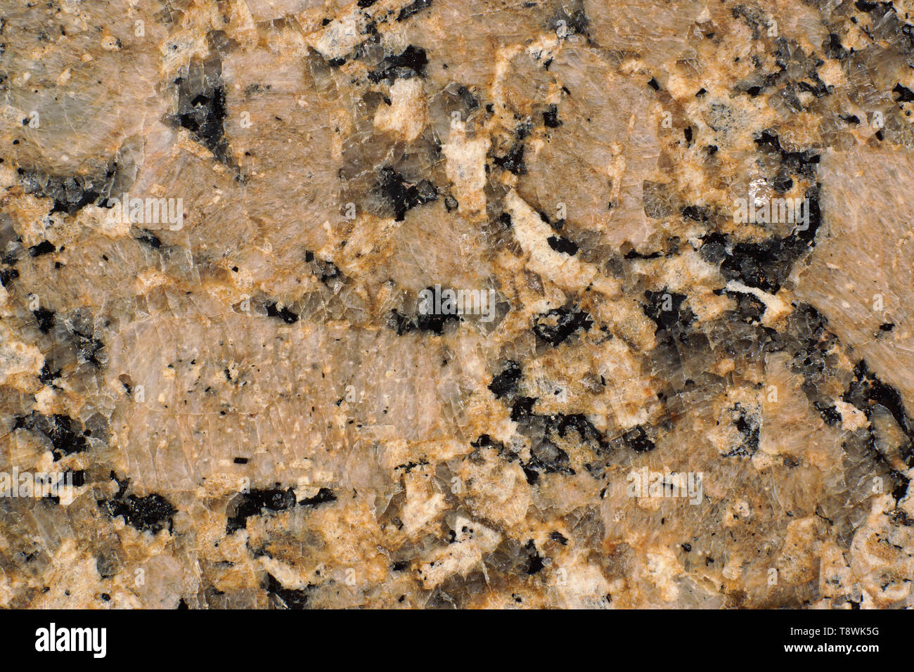 Natural stone yellow-brown granite with dark splashes and cracks Stock ...