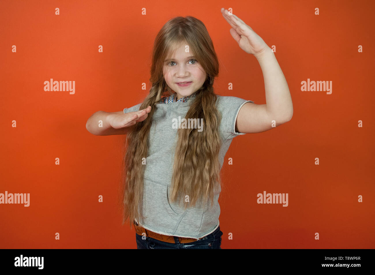 Beautiful girl of primary school age with long dark hair - on an orange ...