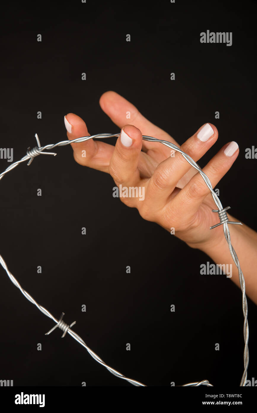 Female hand holding barbed wire, an immigration concept Stock Photo - Alamy