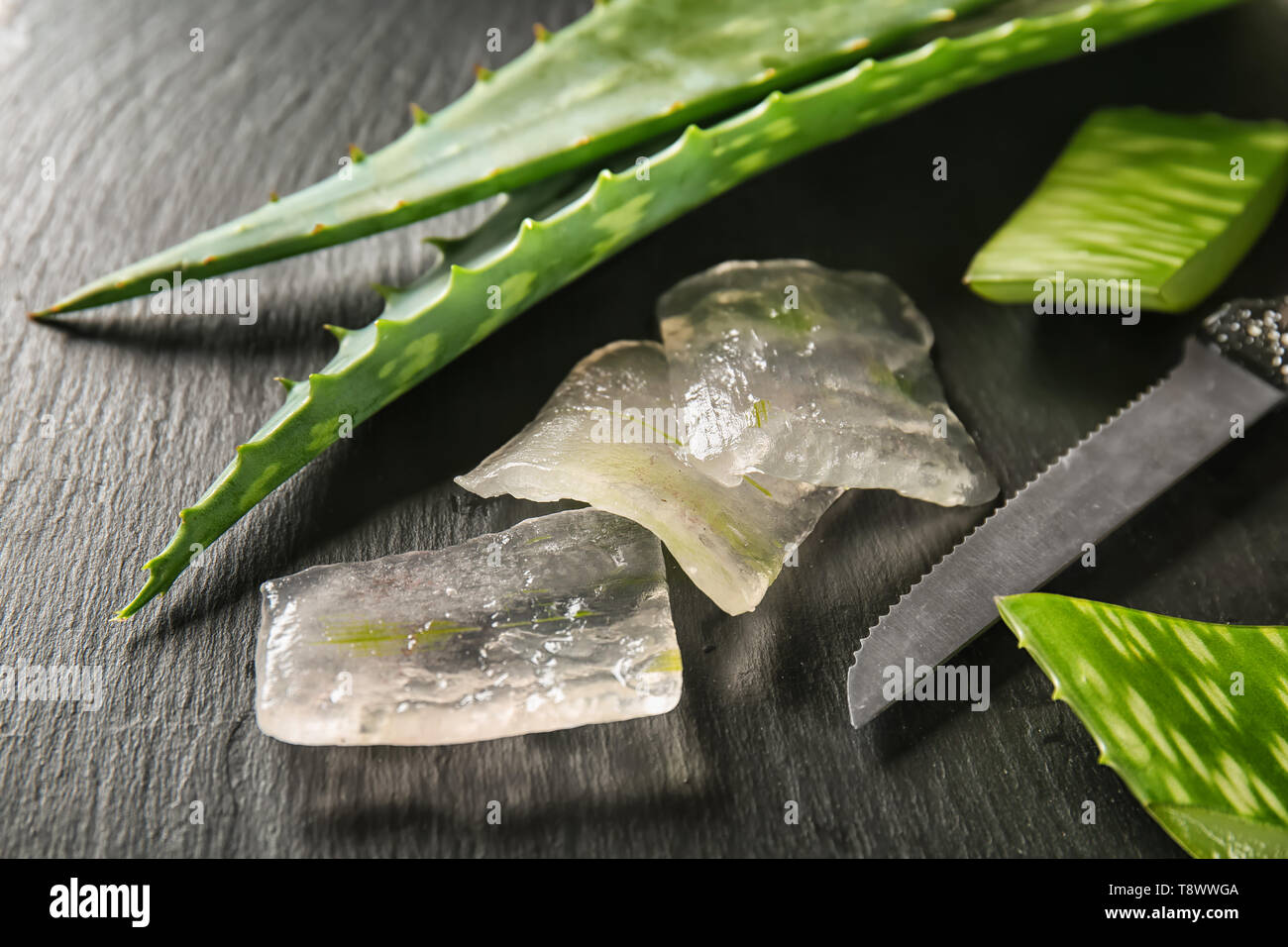 Cut Aloe vera with knife on dark table Stock Photo - Alamy