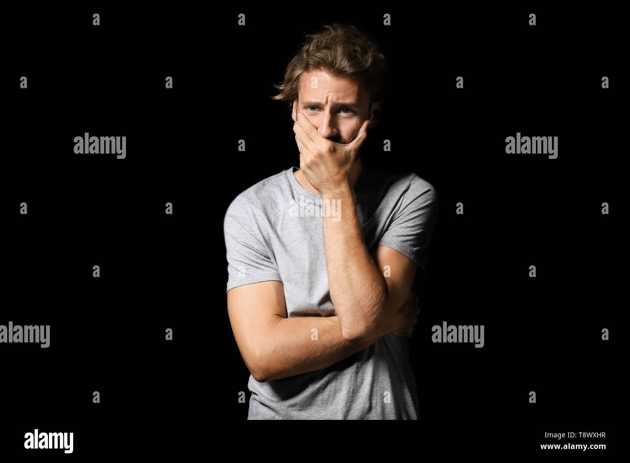 Stressed young man on dark background Stock Photo - Alamy