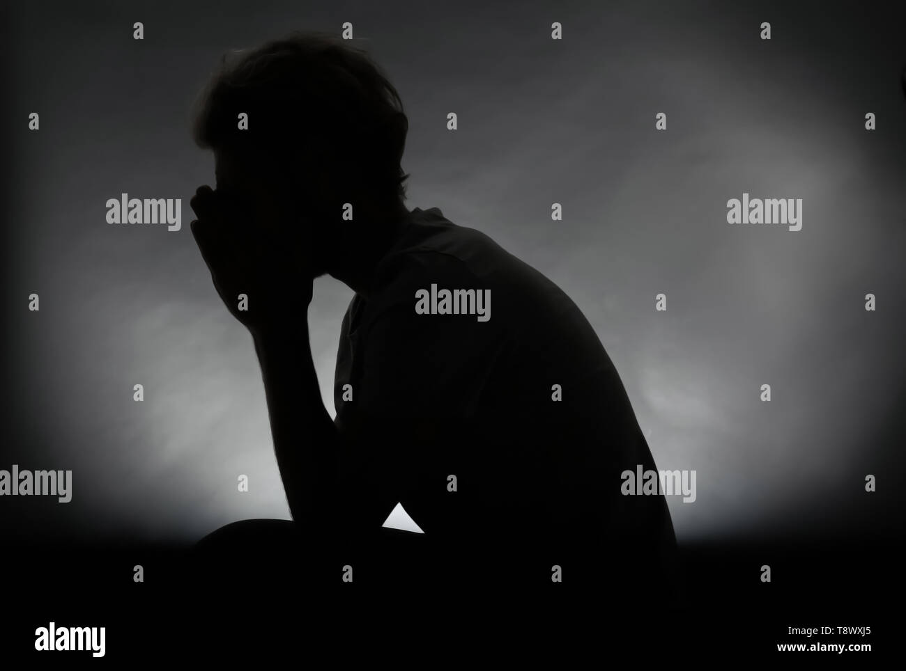 Silhouette of stressed man on dark background Stock Photo - Alamy