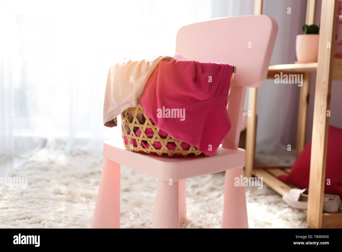 Laundry basket with dirty clothes on chair Stock Photo - Alamy