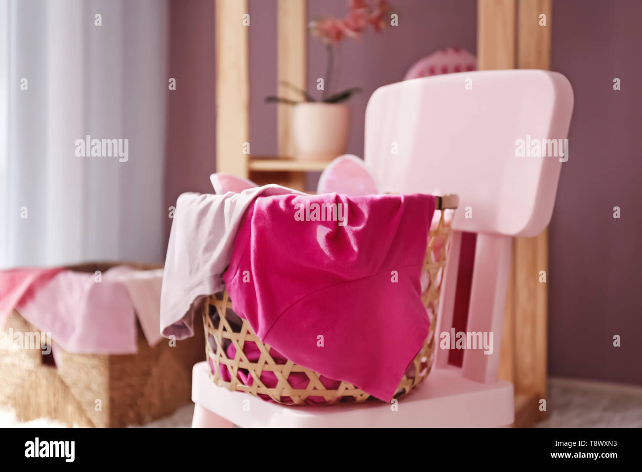 Laundry basket with dirty clothes on chair Stock Photo - Alamy