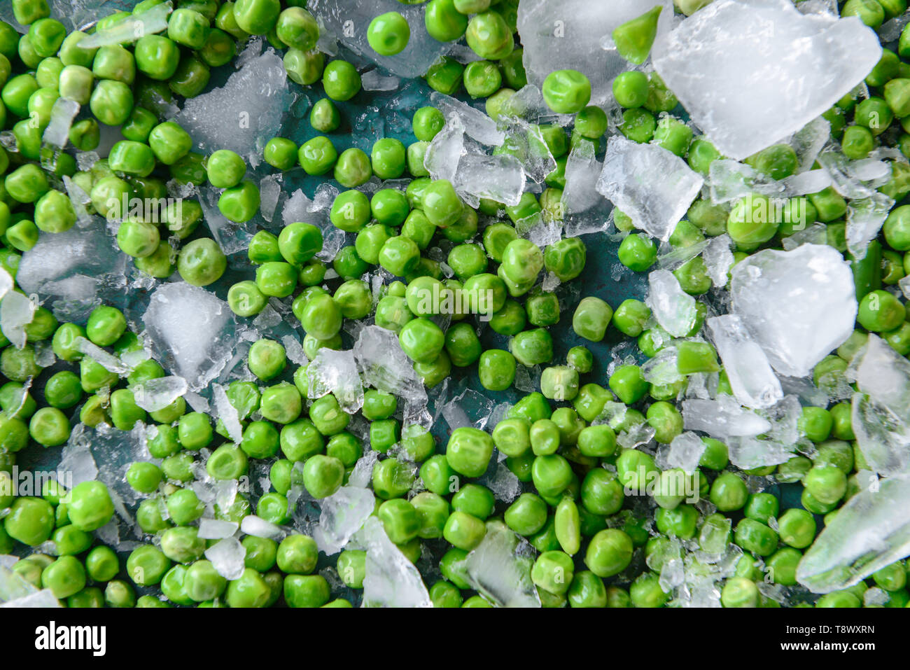 Frozen green peas with ice cubes, top view Stock Photo - Alamy