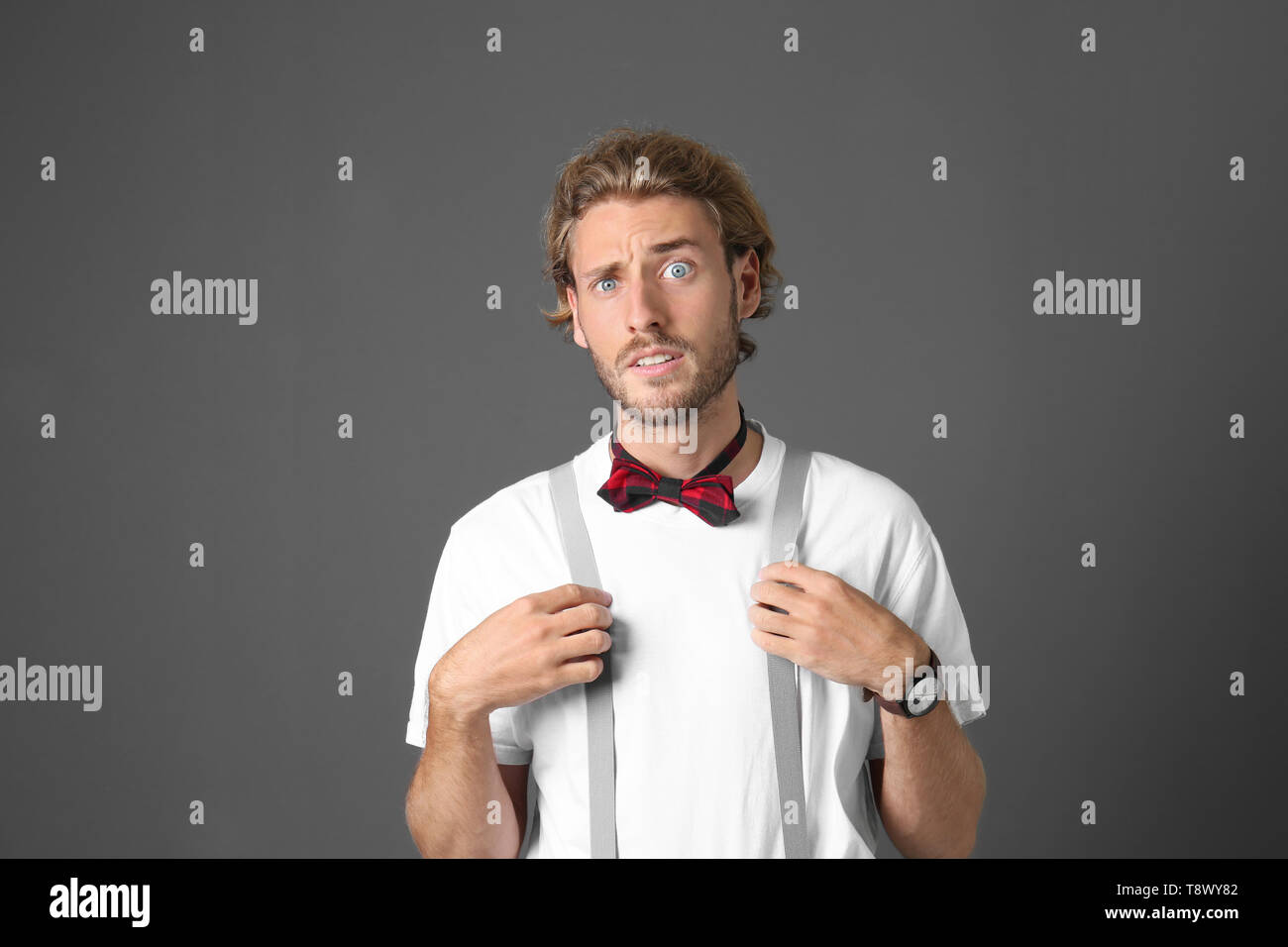 Portrait of handsome mistrustful man on grey background Stock Photo - Alamy