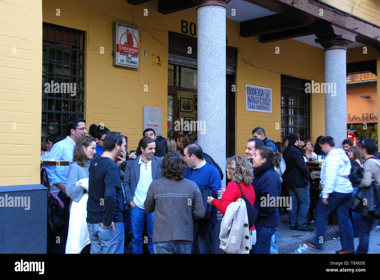 Locals and tourists standing outside a busy tapas bar in the Santa Cruz ...