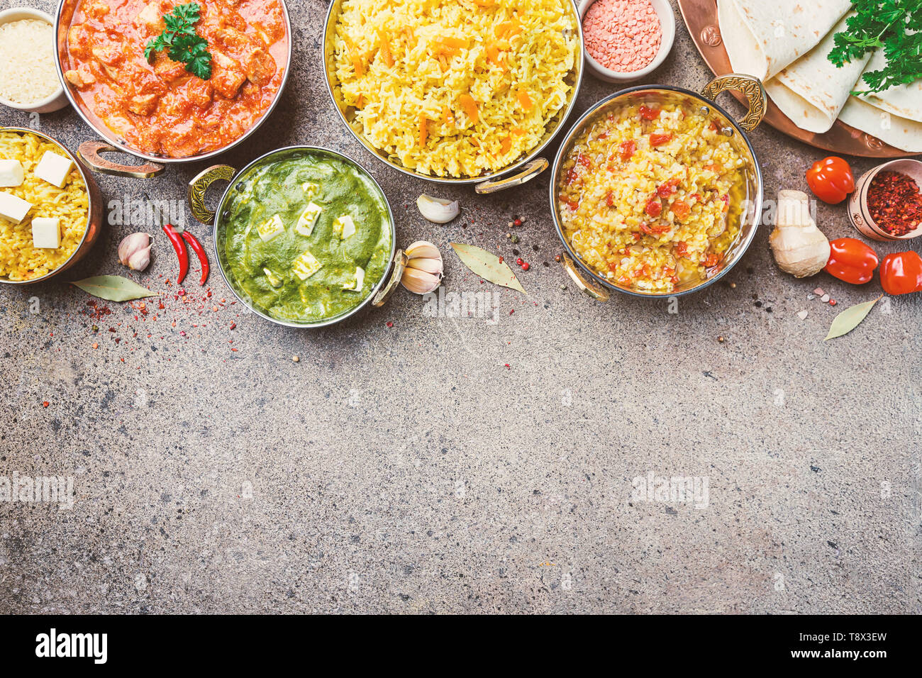 Different bowls with assorted indian food on gray stone background, top ...