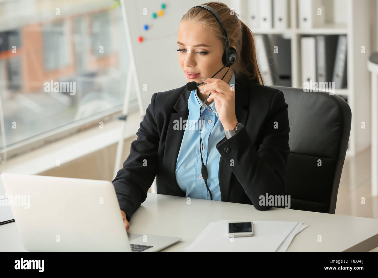 Beautiful female secretary talking through headset in office Stock ...