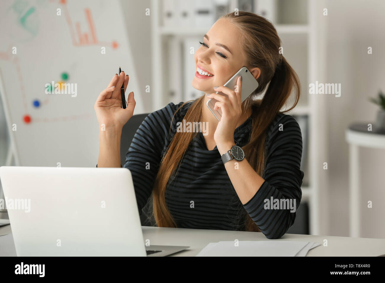 Beautiful female secretary talking on mobile phone in office Stock ...