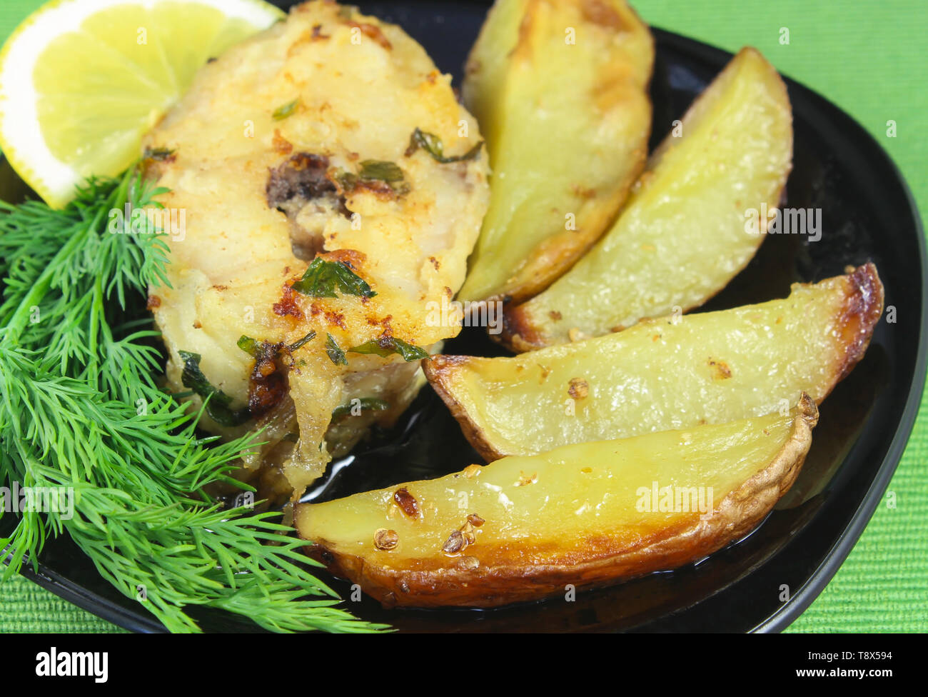 Still-life with fried fish and baked potatoes on a platter Stock Photo ...