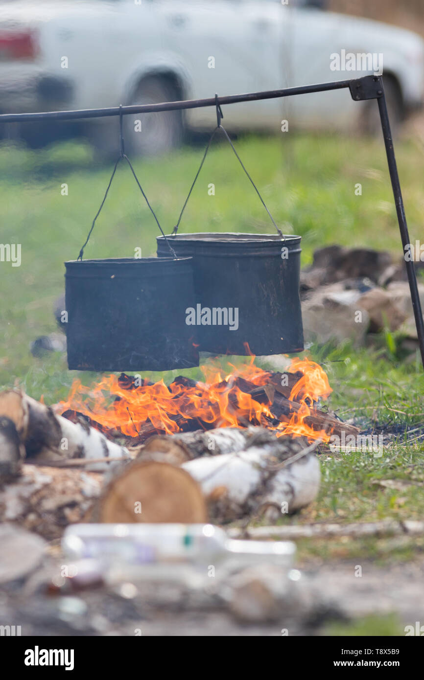 People heating up water in the metal buckets using a bonfire. Buckets ...