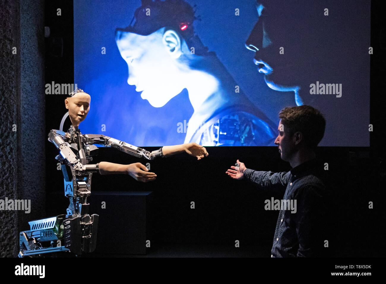 A man interacts with 'Alter', a machine body with a human like face and ...