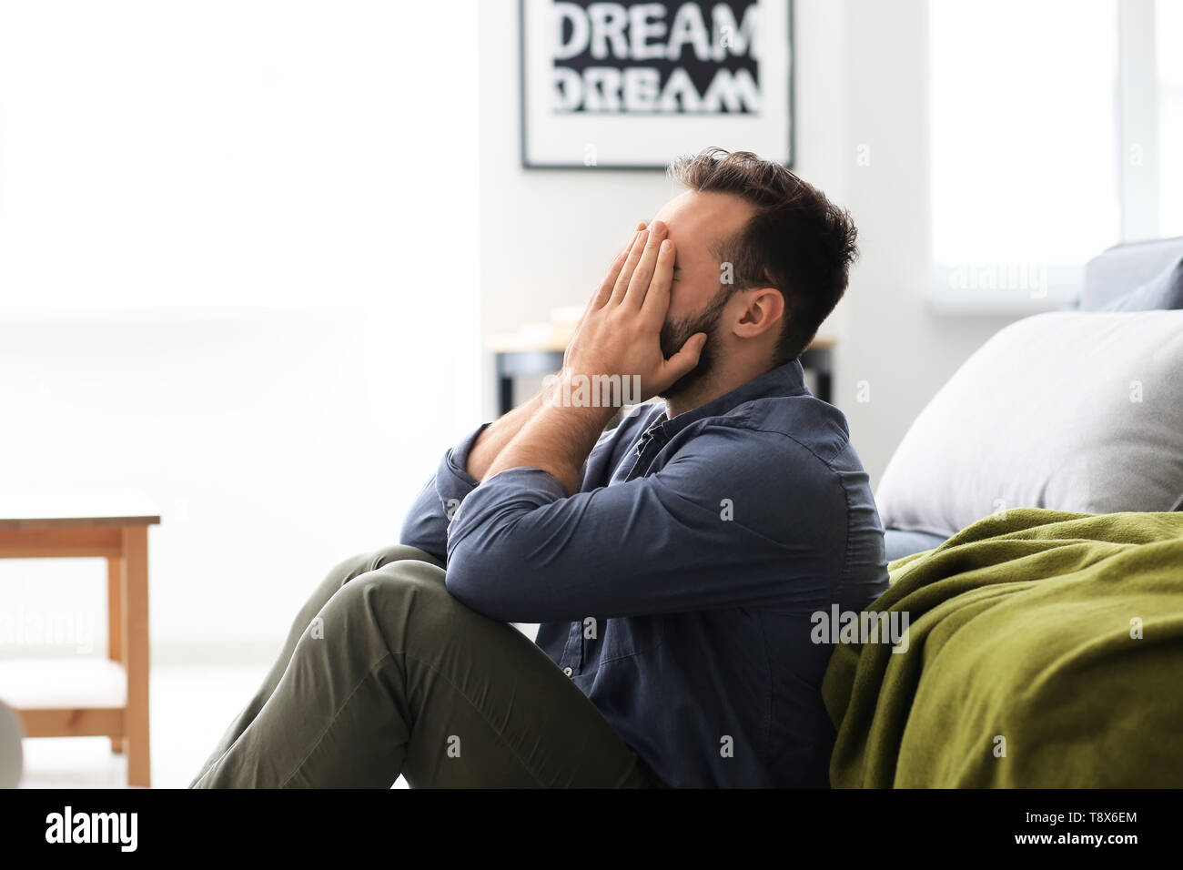 Stressed man sitting on floor at home Stock Photo - Alamy