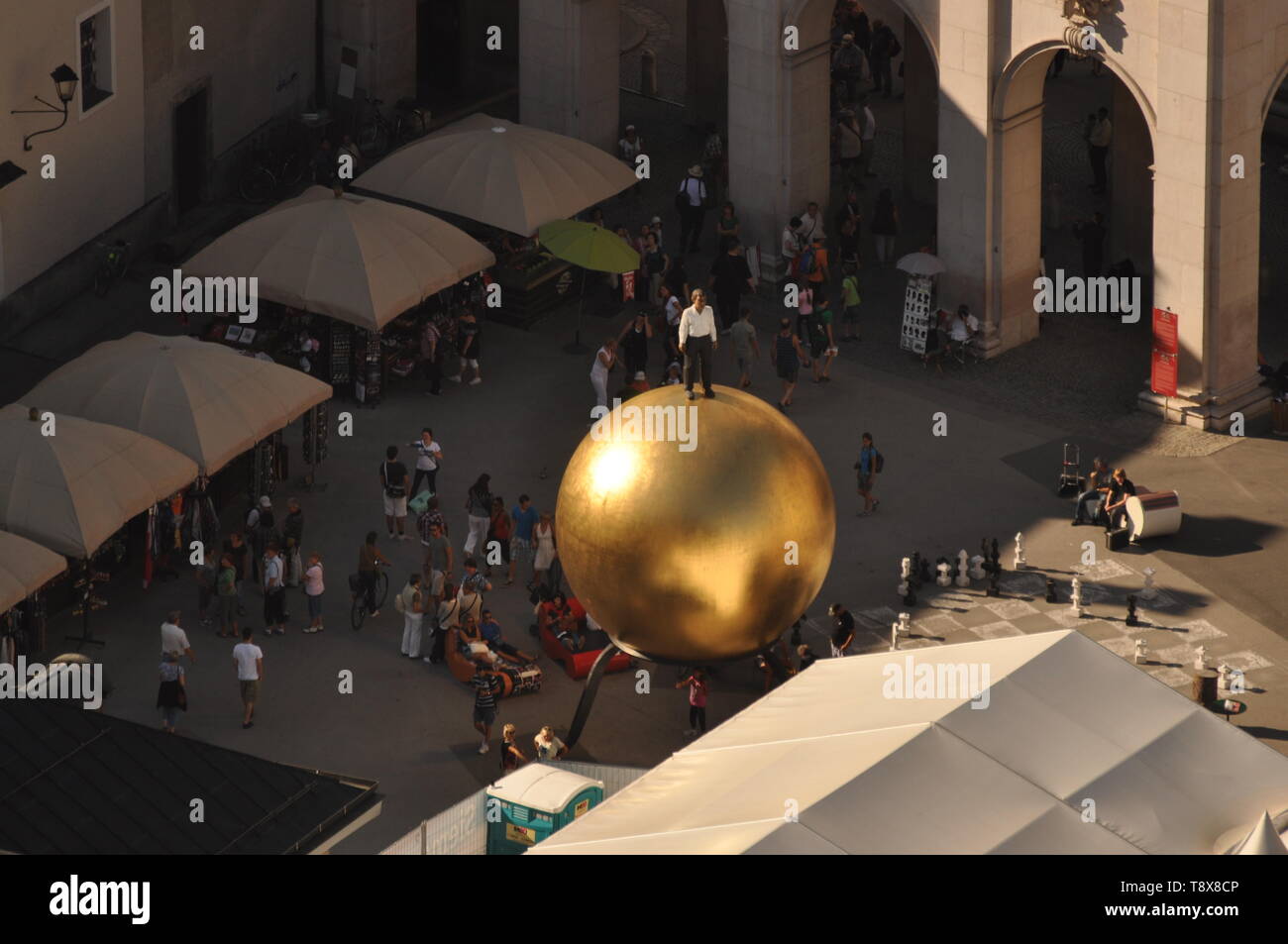 Statue of a big gold ball in the city market Stock Photo - Alamy